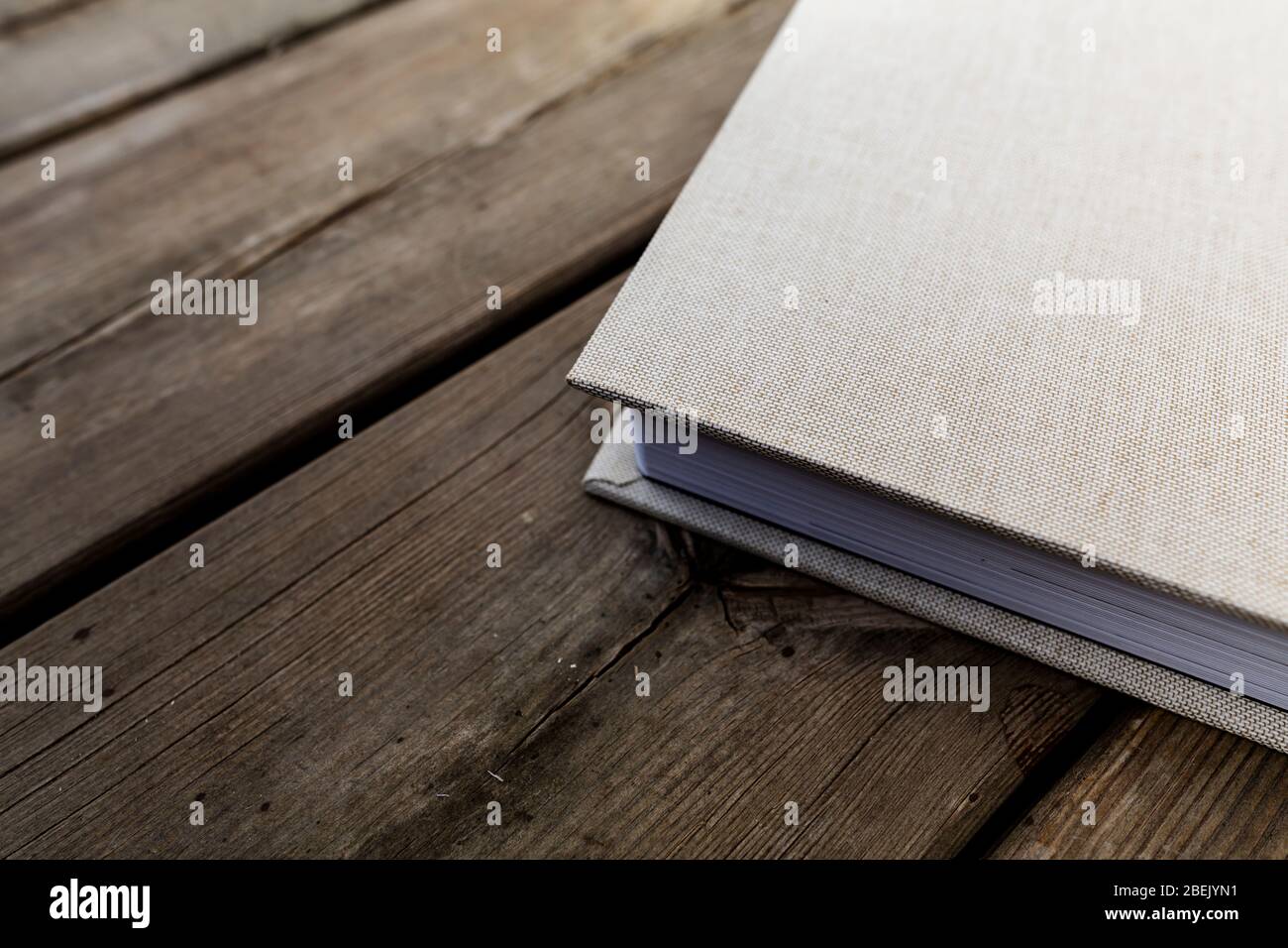 Wedding albums on beautiful wood background. Cloth cover without names ...