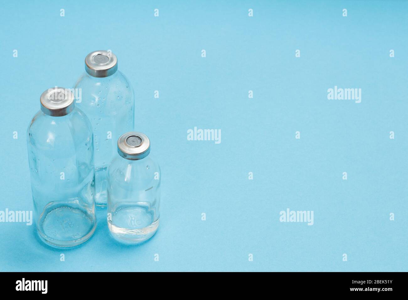 Glass bottles for liquid medicine for injection on a blue background ...