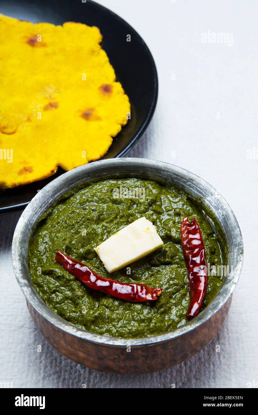 Delicious bowl of sarso ka saag with makki ki roti kept on a table ...