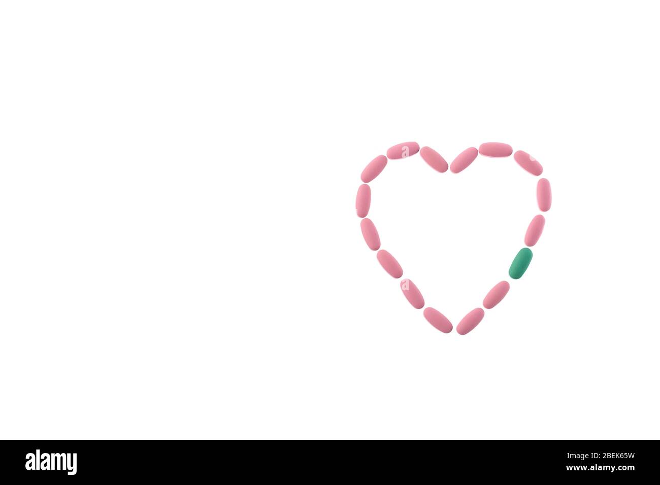 Pink pills in the shape of a heart on a white isolated background ...