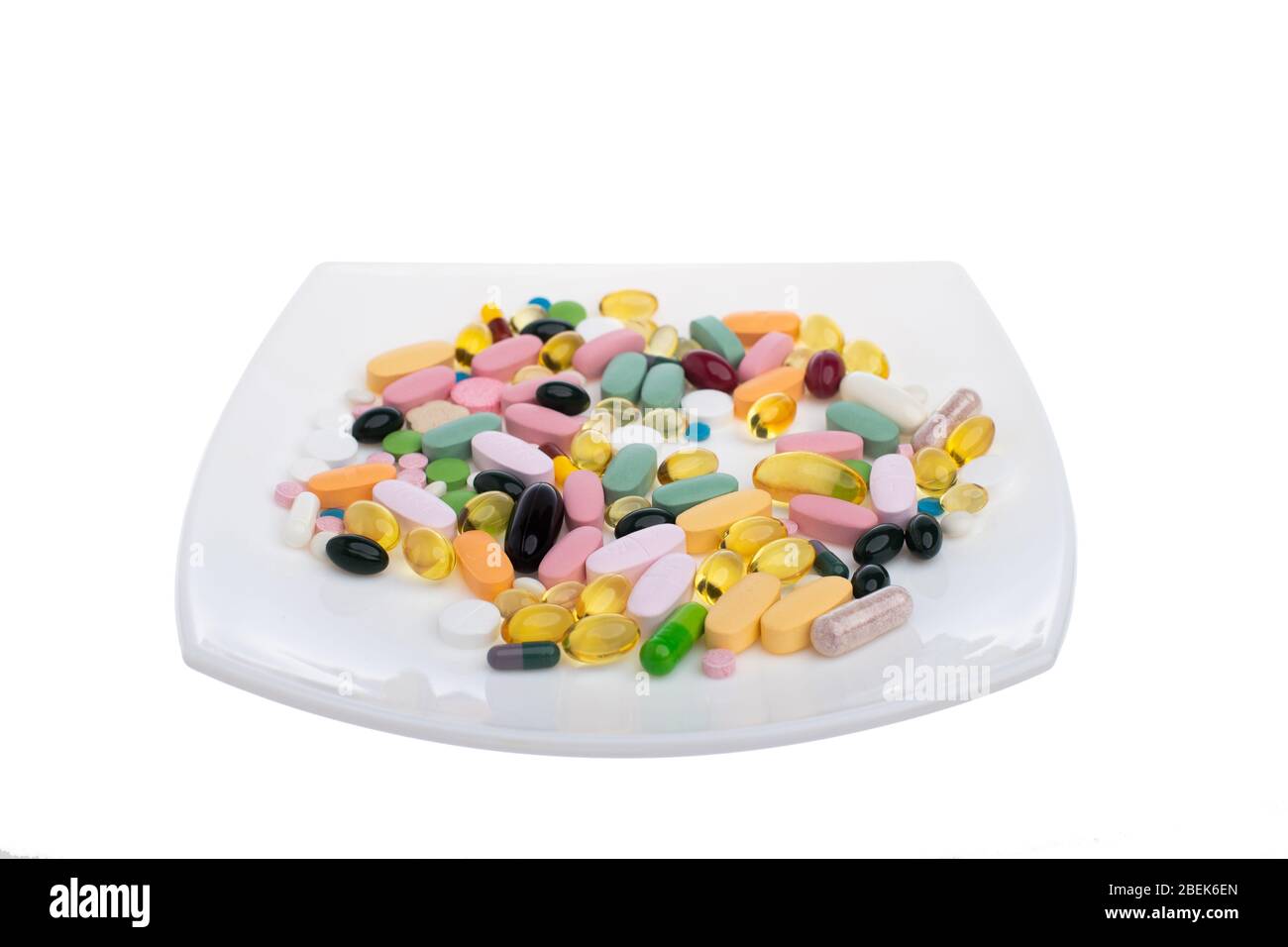 A pile of multi-colored pills on a white plate symbolizing food ...