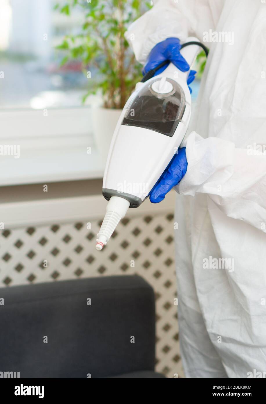 Cleaner in biohazard suit disinfecting room Stock Photo - Alamy