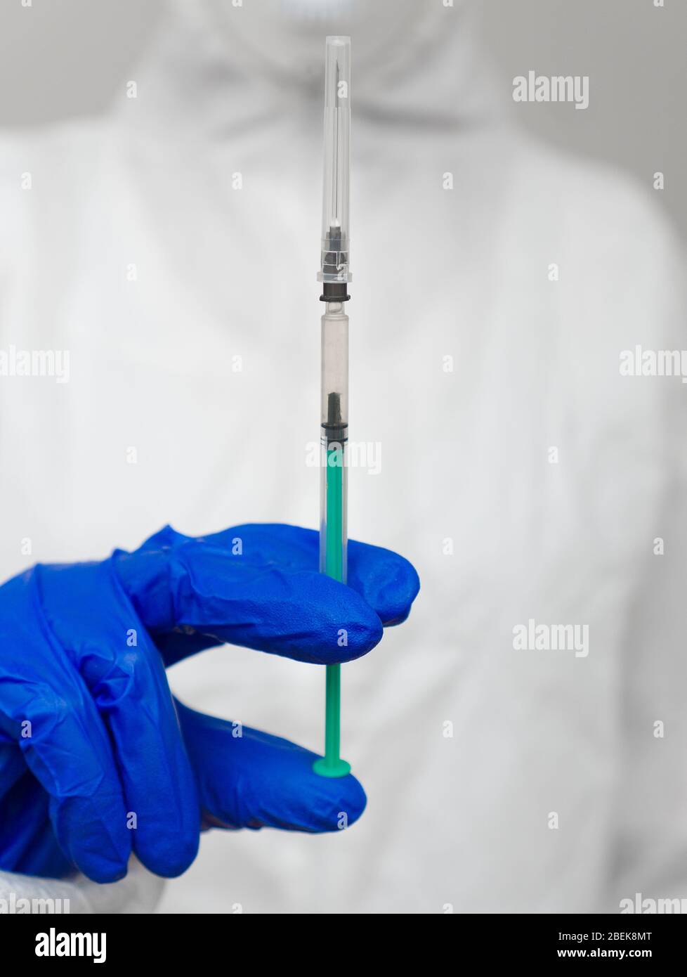 Human in biohazard suit holding syringe Stock Photo - Alamy
