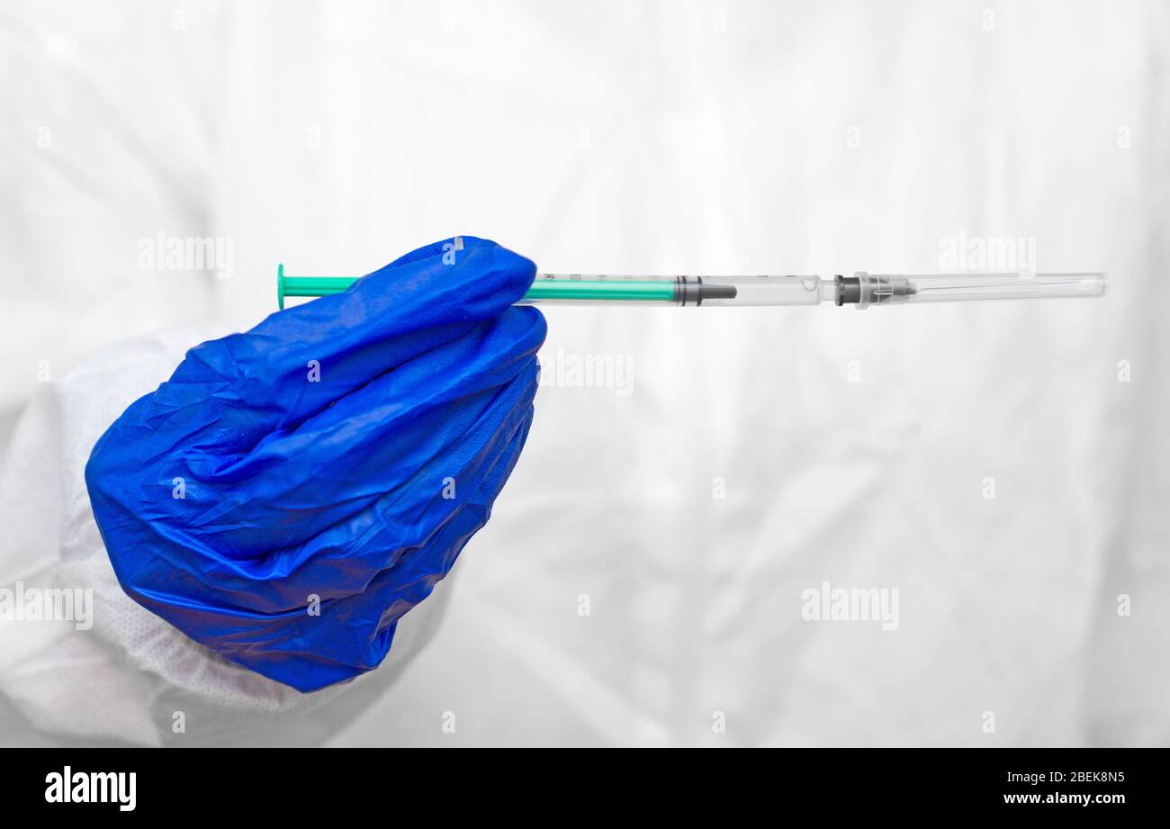 Human in biohazard suit holding syringe Stock Photo - Alamy
