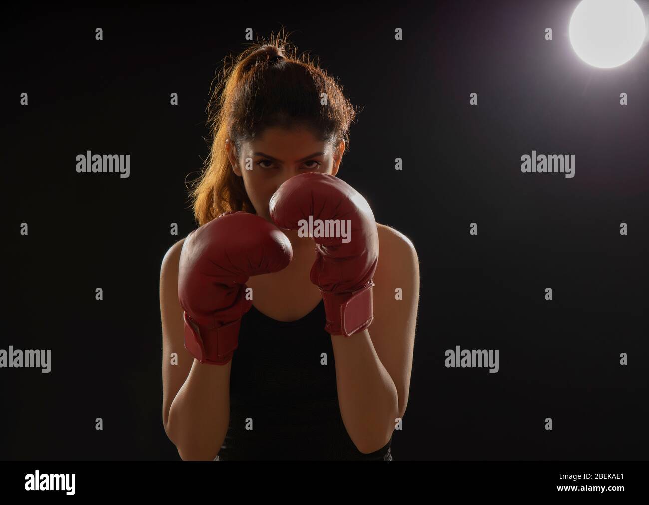 Woman wearing boxing gloves ready to throw a punch Stock Photo - Alamy