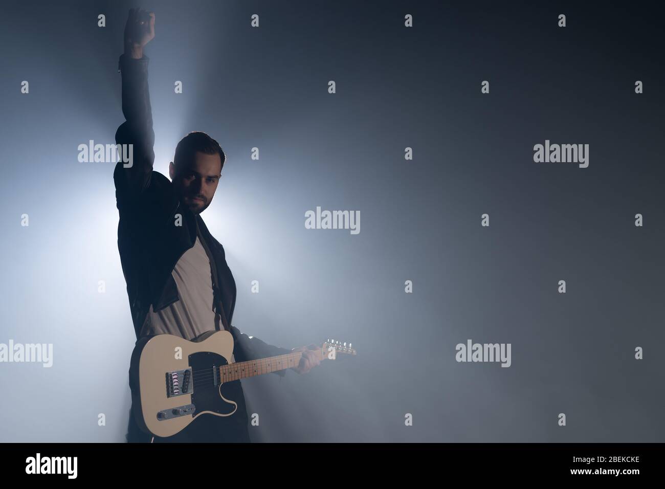 Rock guitarist man on smoky stage and masterfully playing electric ...