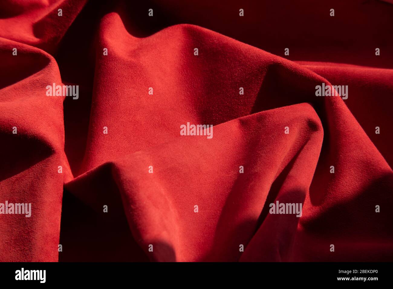 Red matte background of suede fabric, closeup. Velvet texture of ...