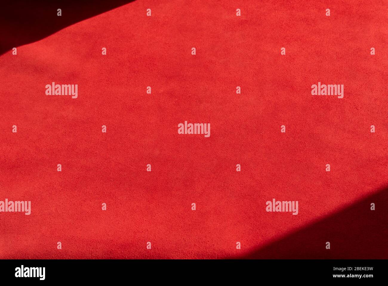 Red matte background of suede fabric, closeup. Velvet texture of ...