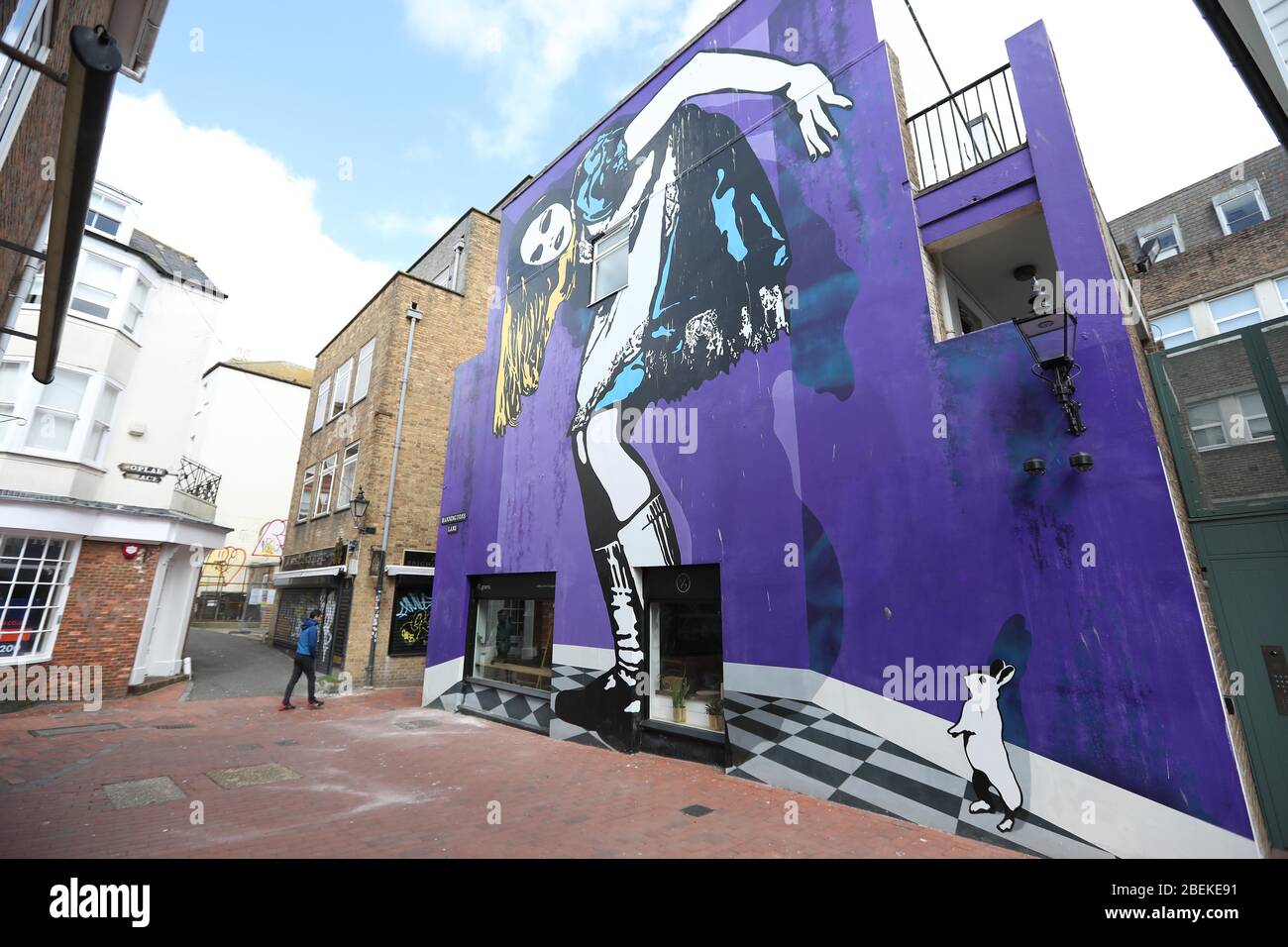 Brighton, UK. 14th Apr, 2020. A person walks past a giant mural of ...