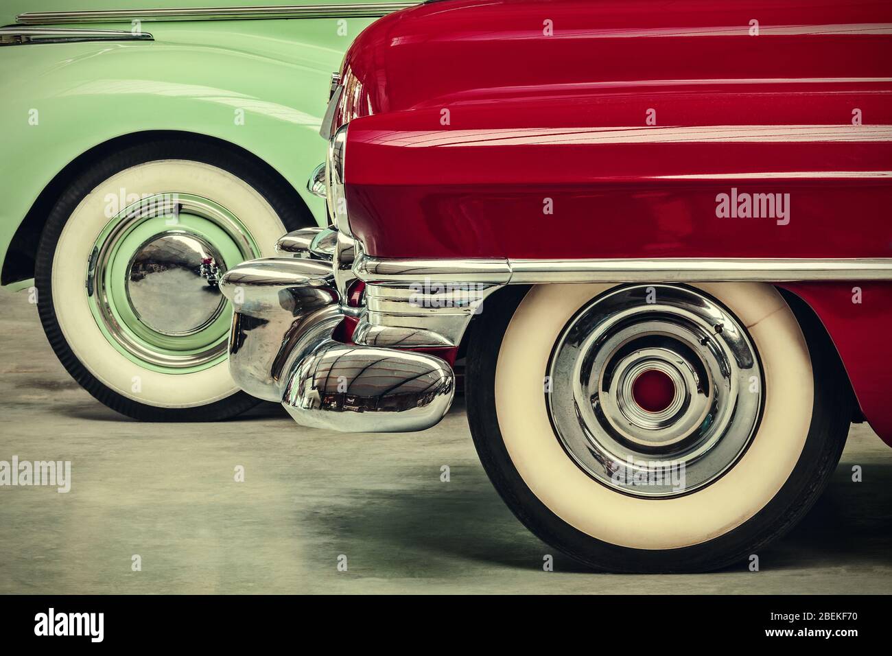 retro styled image of two vintage American cars parked next to each ...