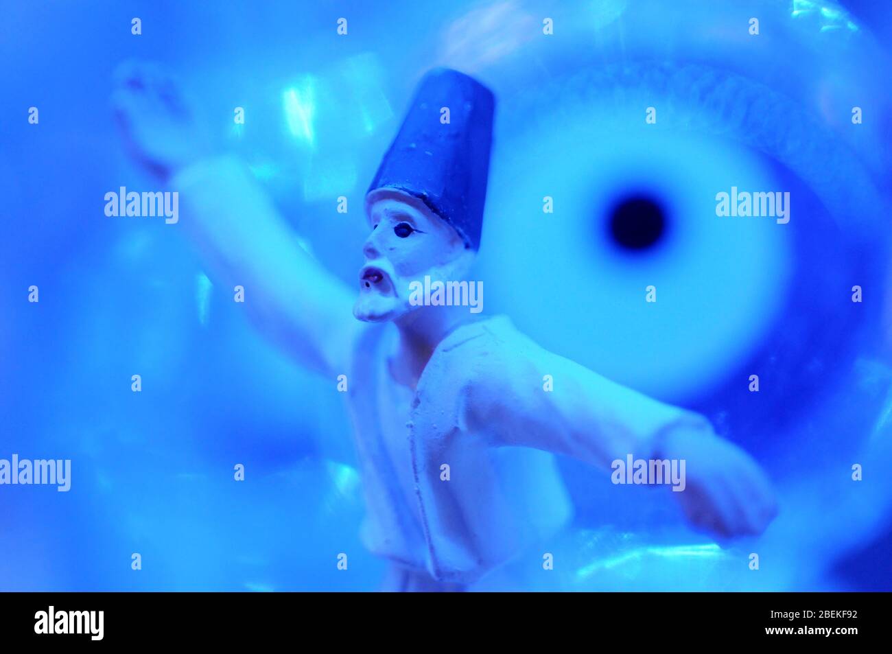The little figure of dancing dervish on blue background Stock Photo - Alamy
