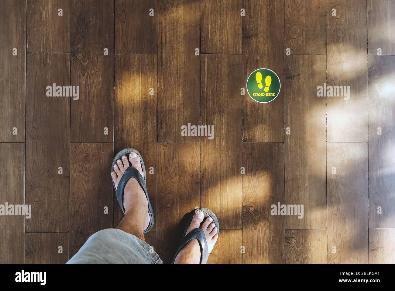 STAND HERE foot sign or symbol on the wooden floor in coffee shop ...
