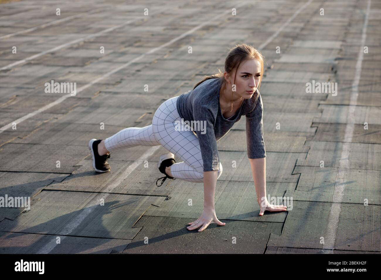 Female runner stretching legs on running track Stock Photo - Alamy
