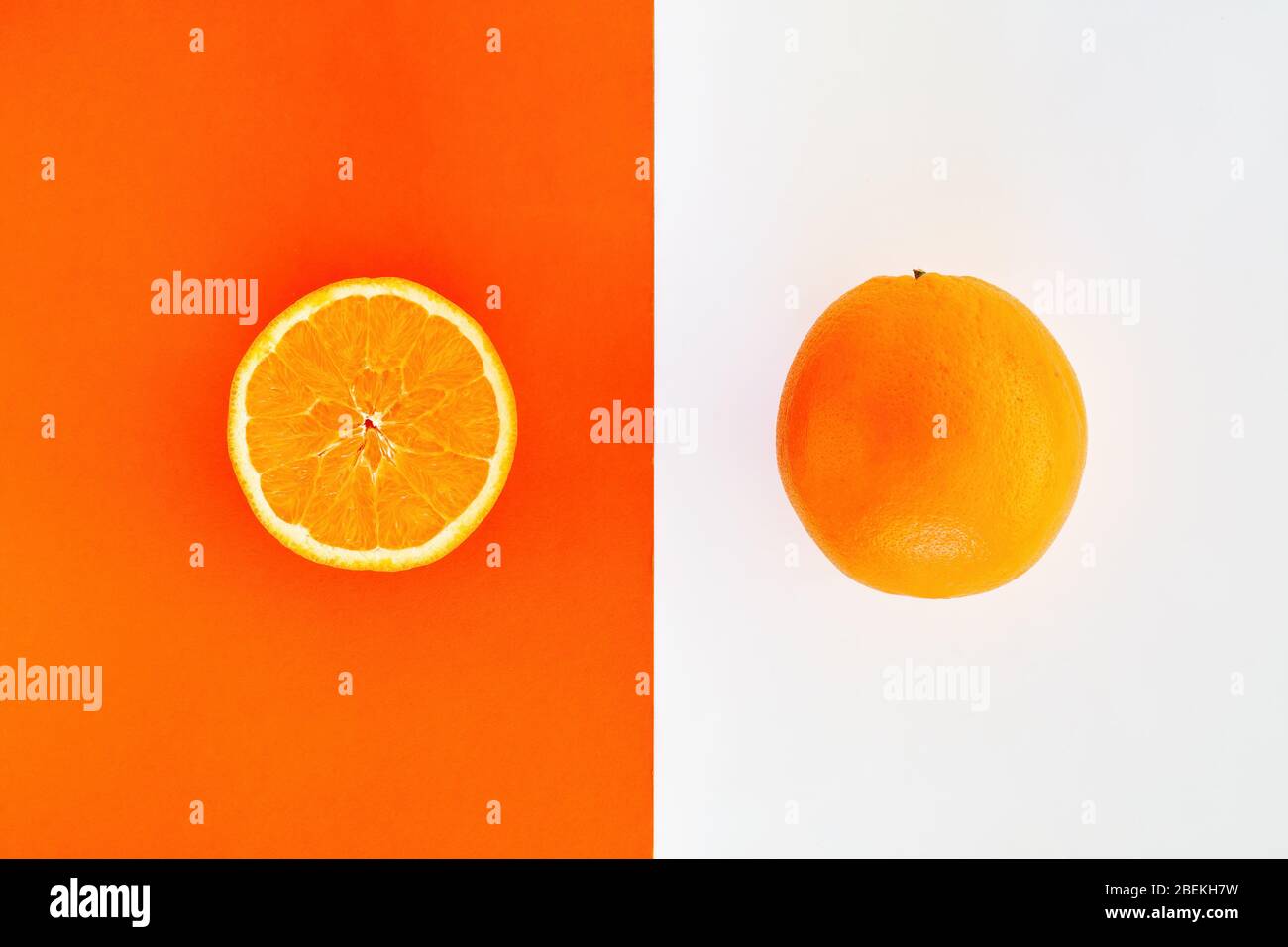 One whole and one half slice of orange comparison on white and orange ...
