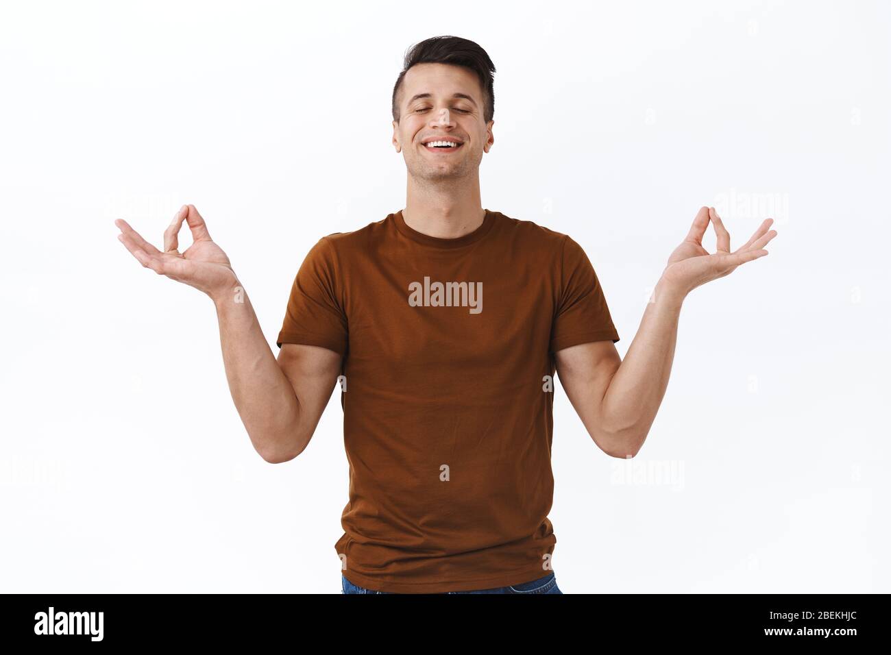 Portrait of relieved and happy, healthy young man smiling with calm and ...