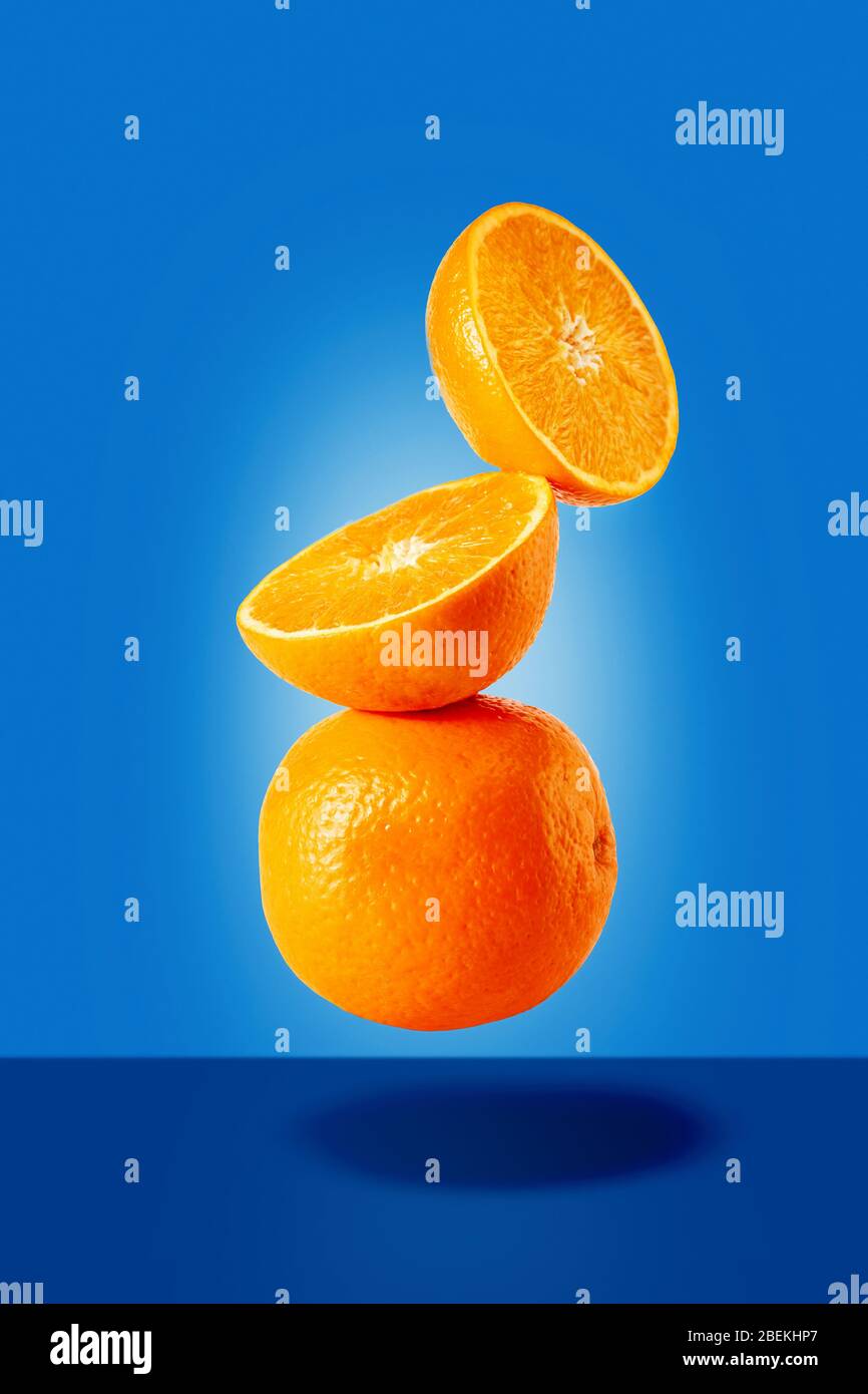 Flying or falling stacked oranges in air on blue background Stock Photo ...