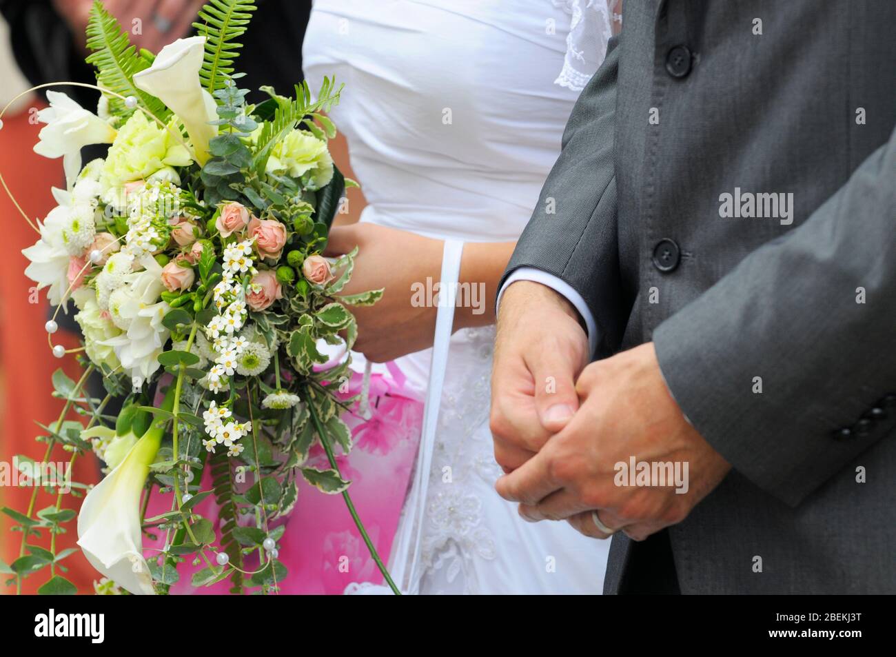 The wedding flower in bride's hands during ceremony Stock Photo - Alamy