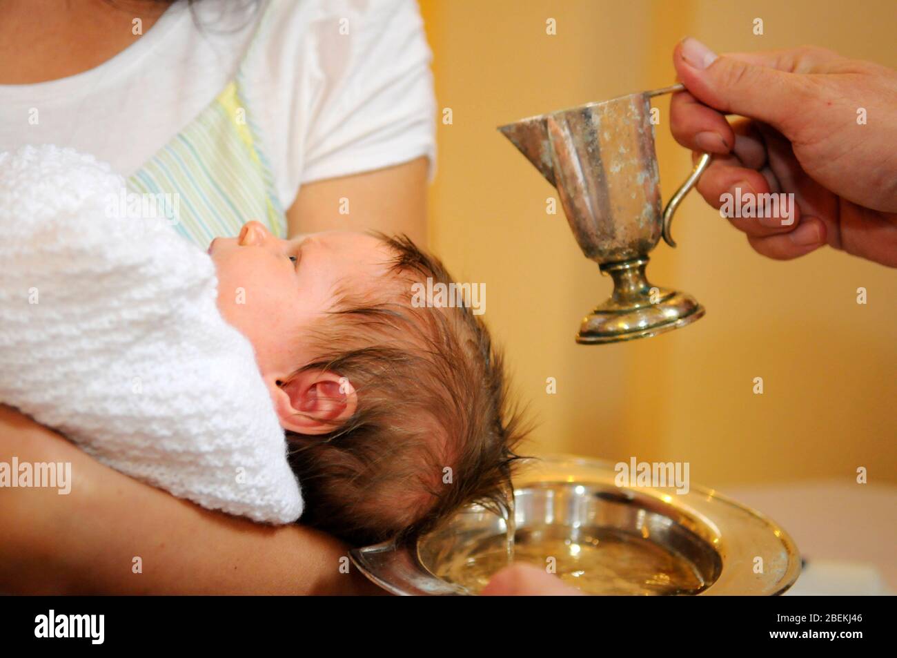 The baptism of little baby with blessed water from iron jug Stock Photo ...