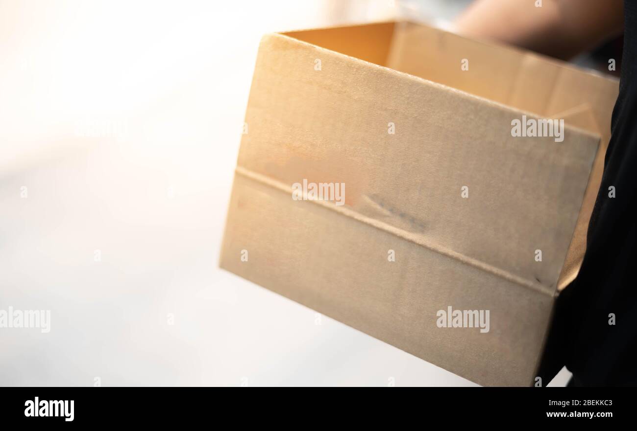 Delivery man hand carrying cardboard box packaging for logistic ...