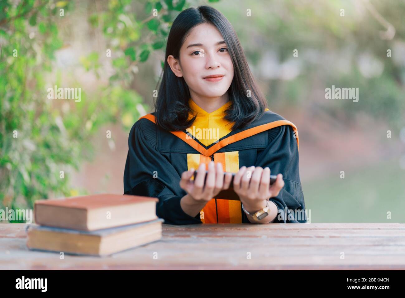 Young charming Asian female graduates celebrate her degree graduation ...