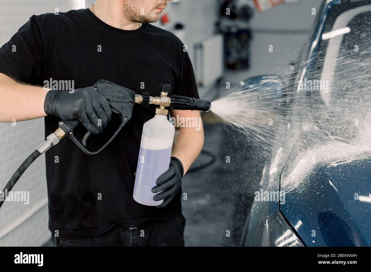 Car wash with flowing water and foam. Side view of young car wash ...