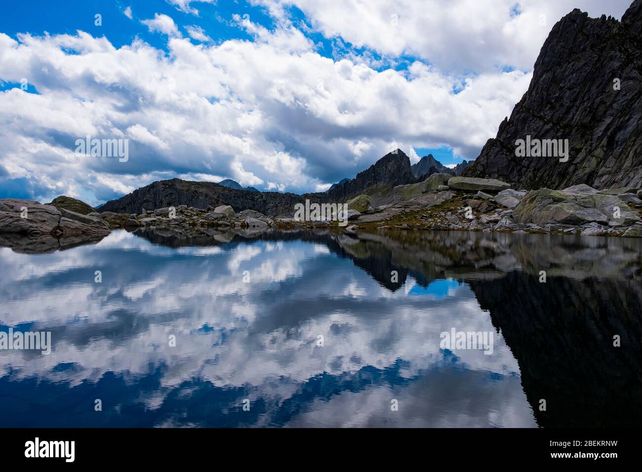 MOUNTAINS AND CLOUDS REFLECTED ON LAKE SAW DURING TREKKING Stock Photo ...