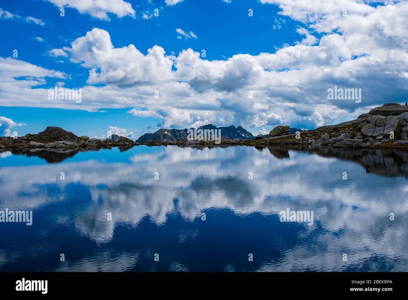 MOUNTAINS AND CLOUDS REFLECTED ON LAKE SAW DURING TREKKING Stock Photo ...