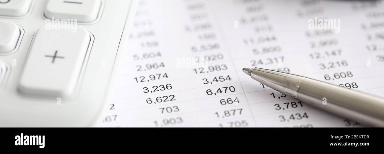Silver pen report with numbers next to calculator Stock Photo - Alamy