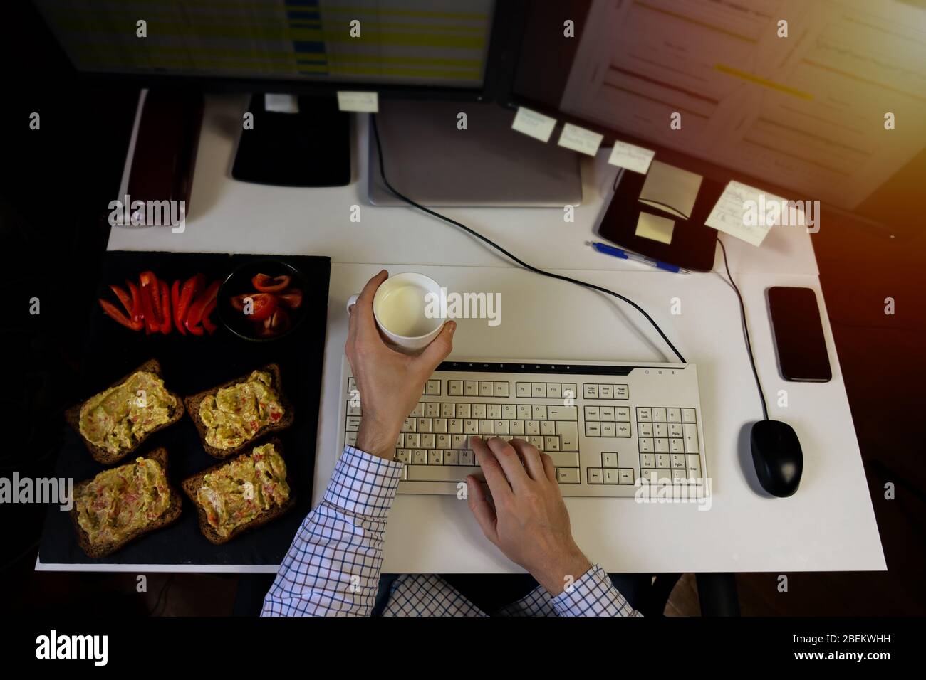 Busy business man eating healthy avocado toast breakfas while working ...