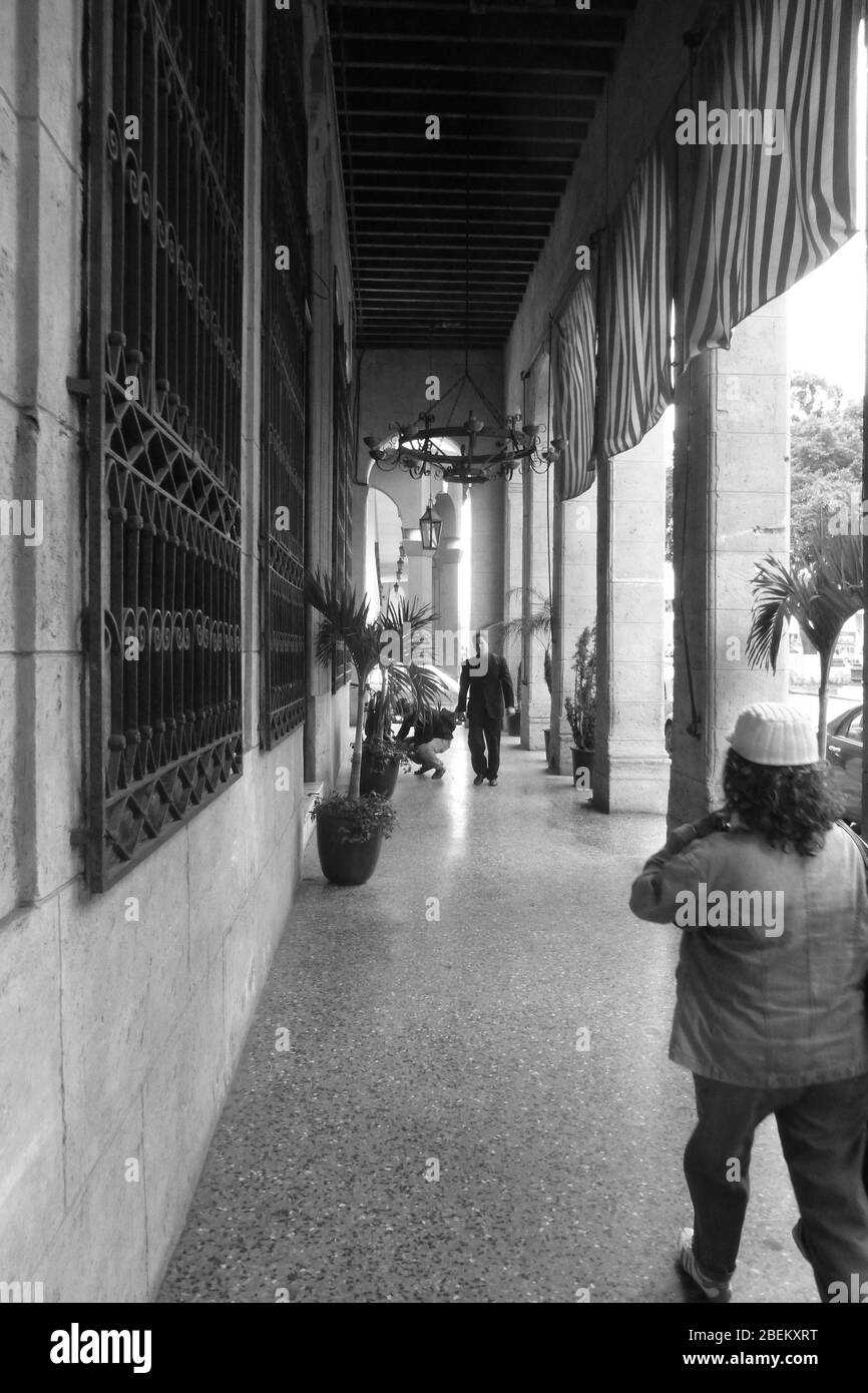 Havana Cuba walkway pillars metal grill pots plants people flag floor ...