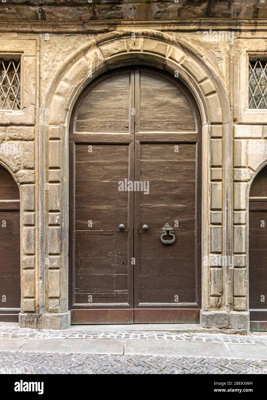 Arched wooden door of an ancient building in the Old City of Bergamo ...