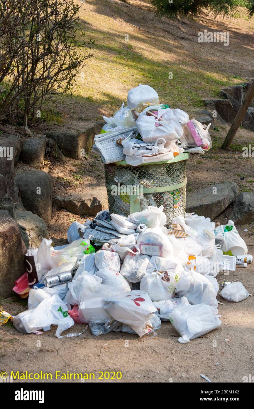Japan. A overflowing litter bin full of litter with many plastic bags ... Japan. A overflowing litter bin full of litter with many plastic bags ...