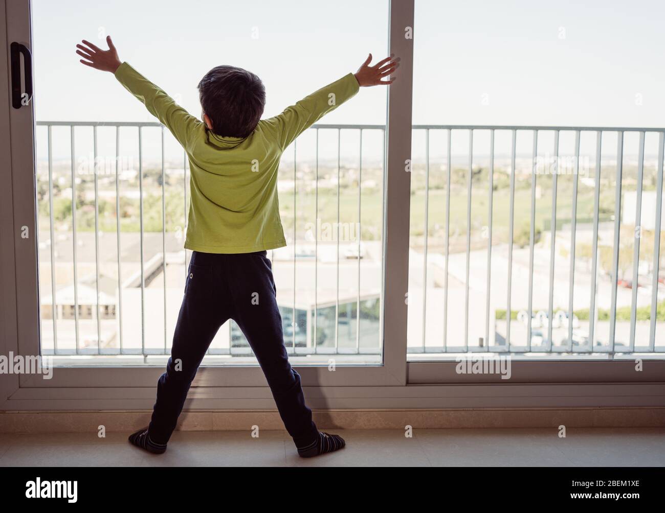 Emotional kid looking outside through the window Stock Photo - Alamy