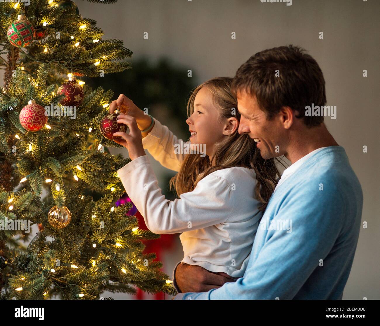 Happy father and daughter decorating a Christmas tree together Stock ...