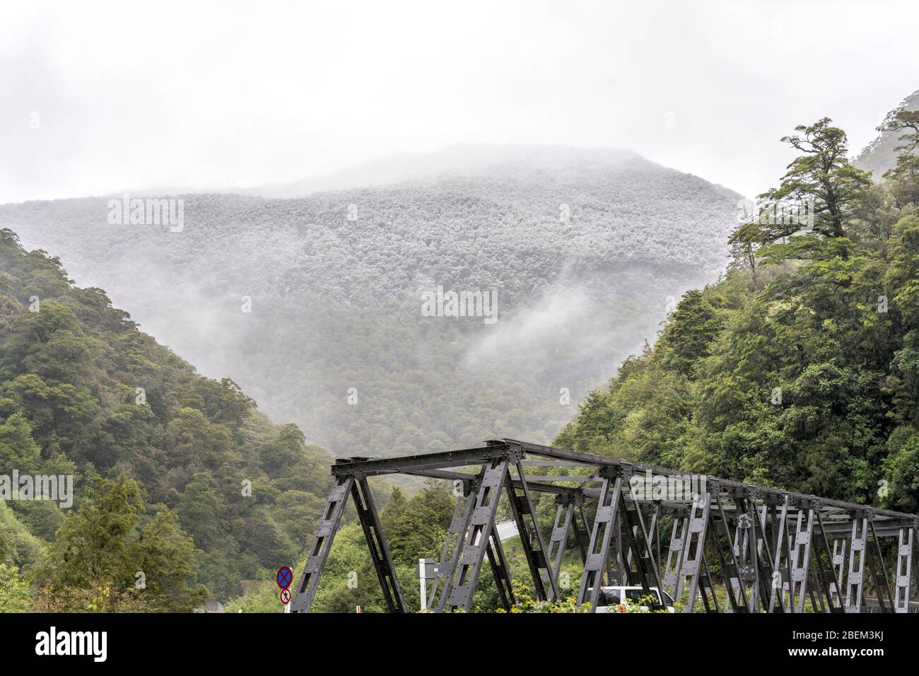 landscape with iron bridge in green forest with recent snow, shot in ...