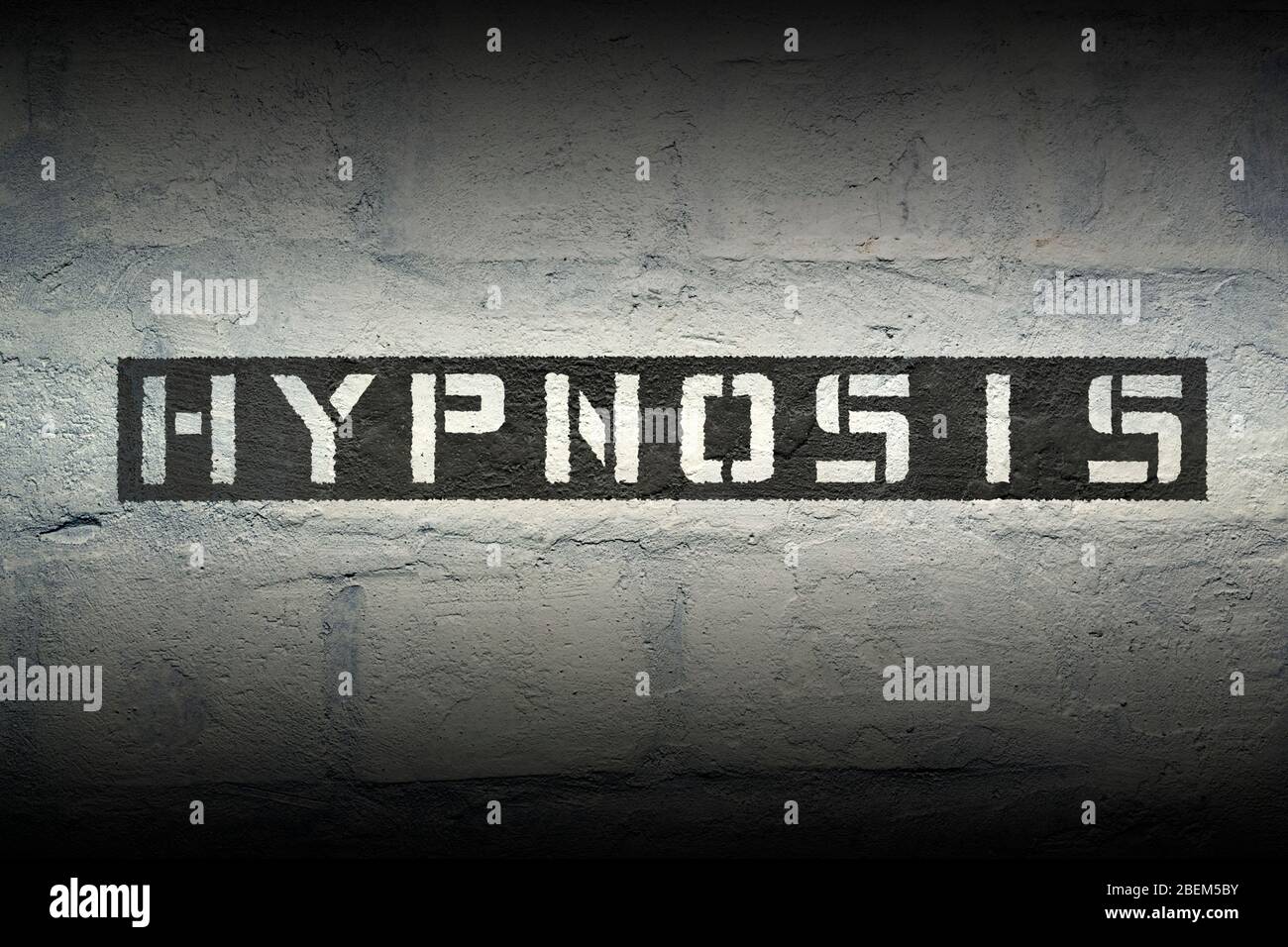 hypnosis stencil print on the grunge white brick wall Stock Photo - Alamy