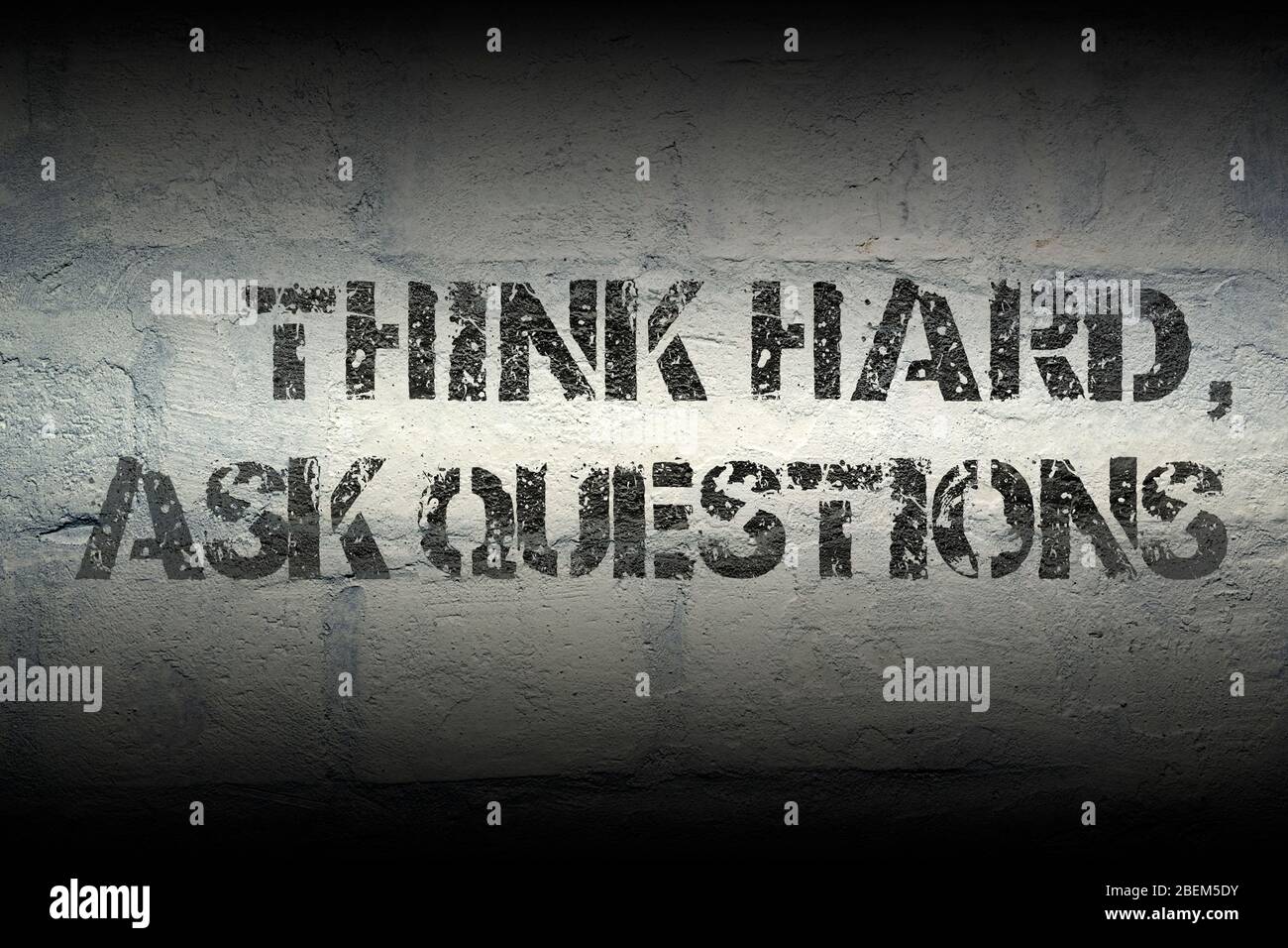 think hard, ask questions stencil print on the grunge white brick wall ...
