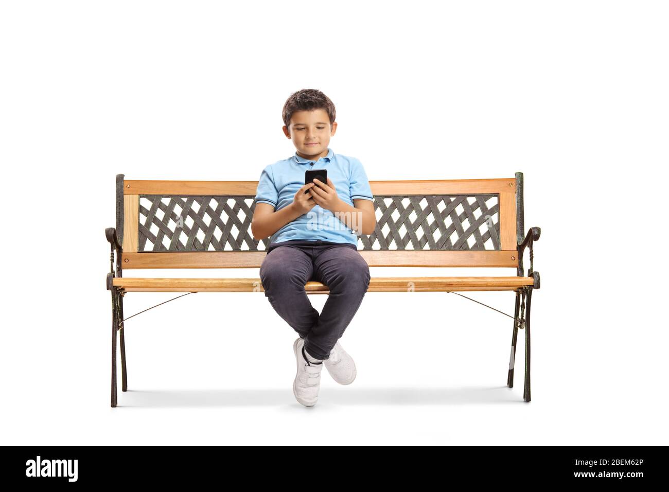 Boy sitting on a bench and using a mobile phone isolated on white ...