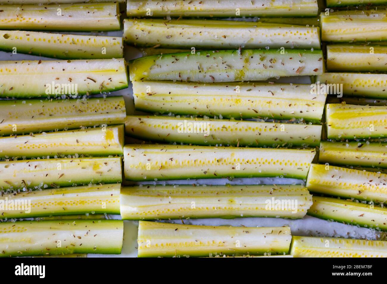 Diced and seasoned fresh zucchini in close up ready for cooking laid ...