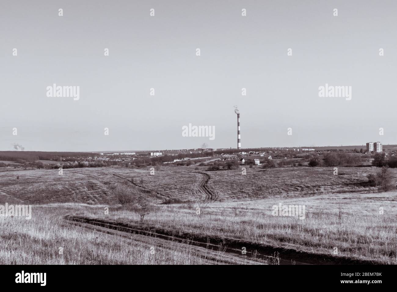 Greyscale field and heat power station pipe with stripes on horizon ...