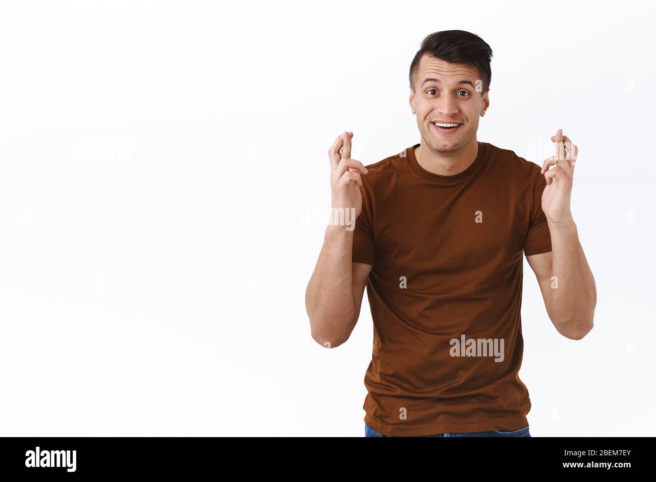 Portrait of optimistic, smiling handsome man praying for dream come ...