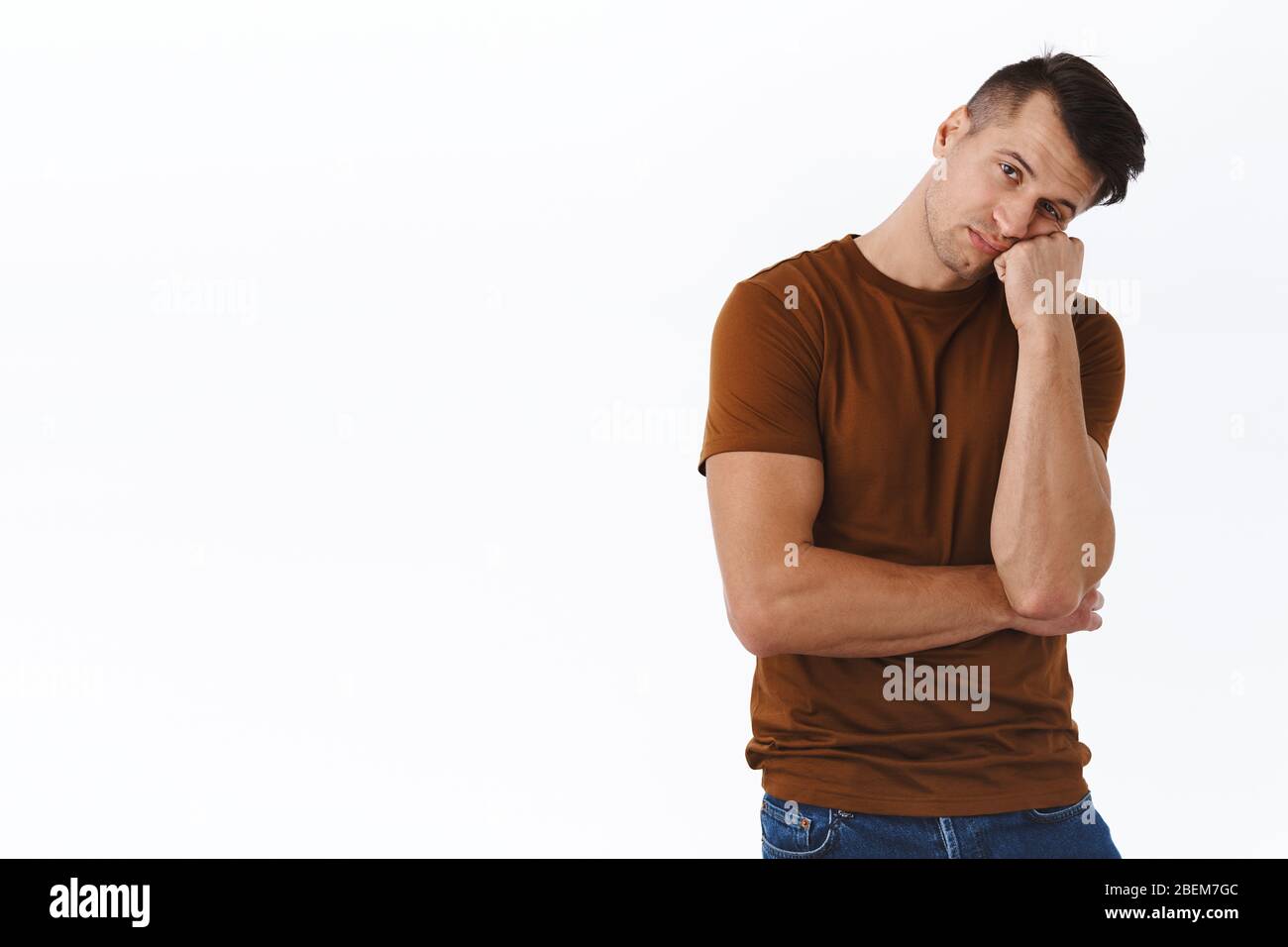 Portrait of bored and sad handsome young man, lean on palm, dont know ...