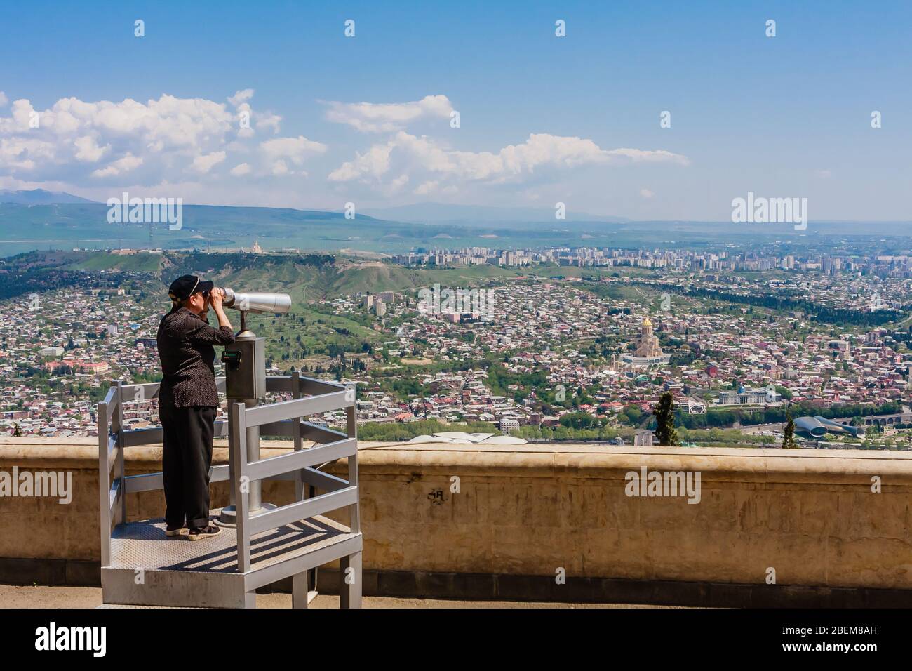 Tourist looking from binocular from Mt Mtatsminda above old Tbilisi ...