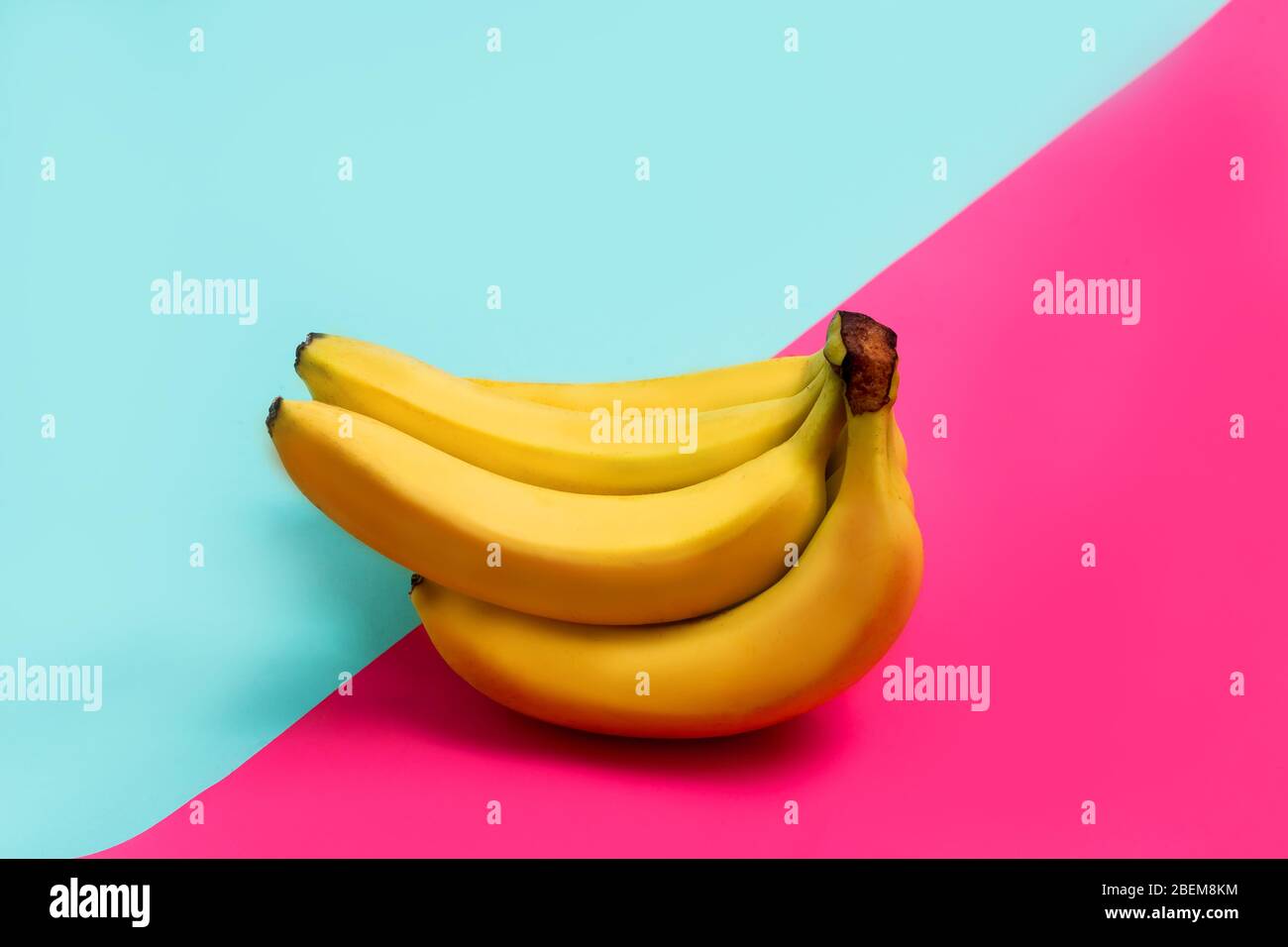 Bunch of bananas on colorful paper background Stock Photo - Alamy
