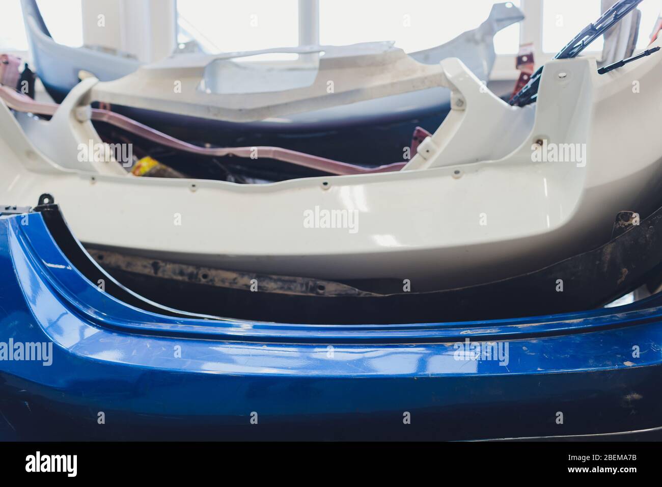 A row of car bumpers of different colors waiting their turn at a auto ...