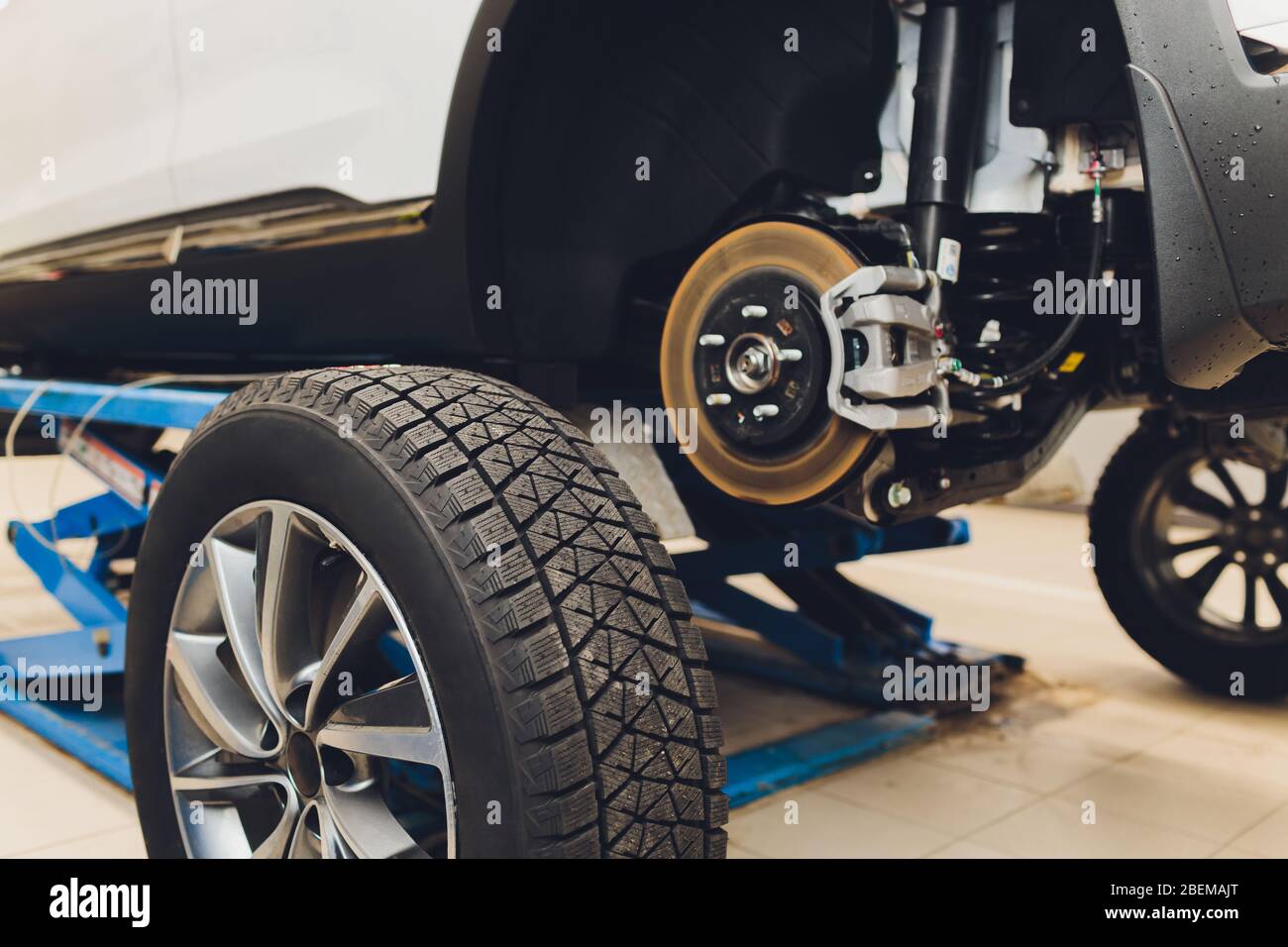 modern car service. back view of car in room service. Wheel replacement ...