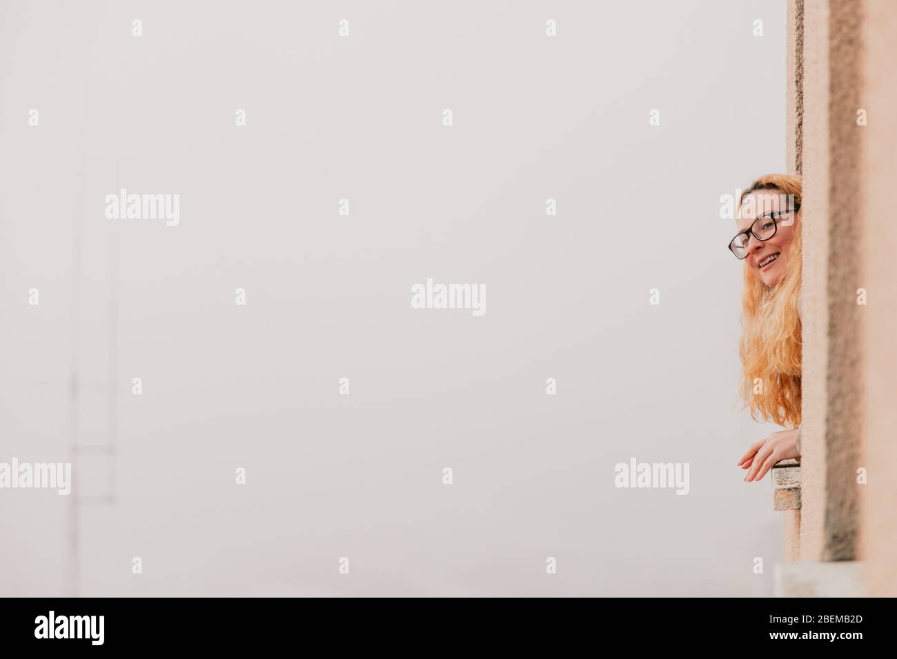 Quarantined woman bending over the window watching outside Stock Photo ...