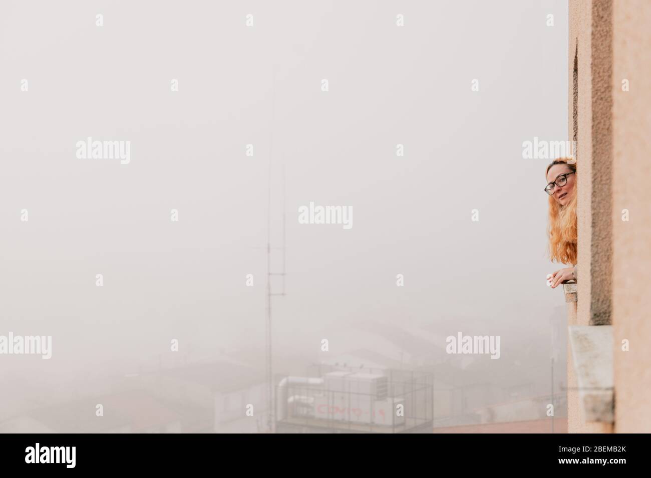 Quarantined woman bending over the window watching outside Stock Photo ...