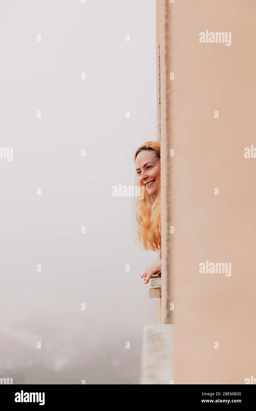 Quarantined woman bending over the window watching outside Stock Photo ...