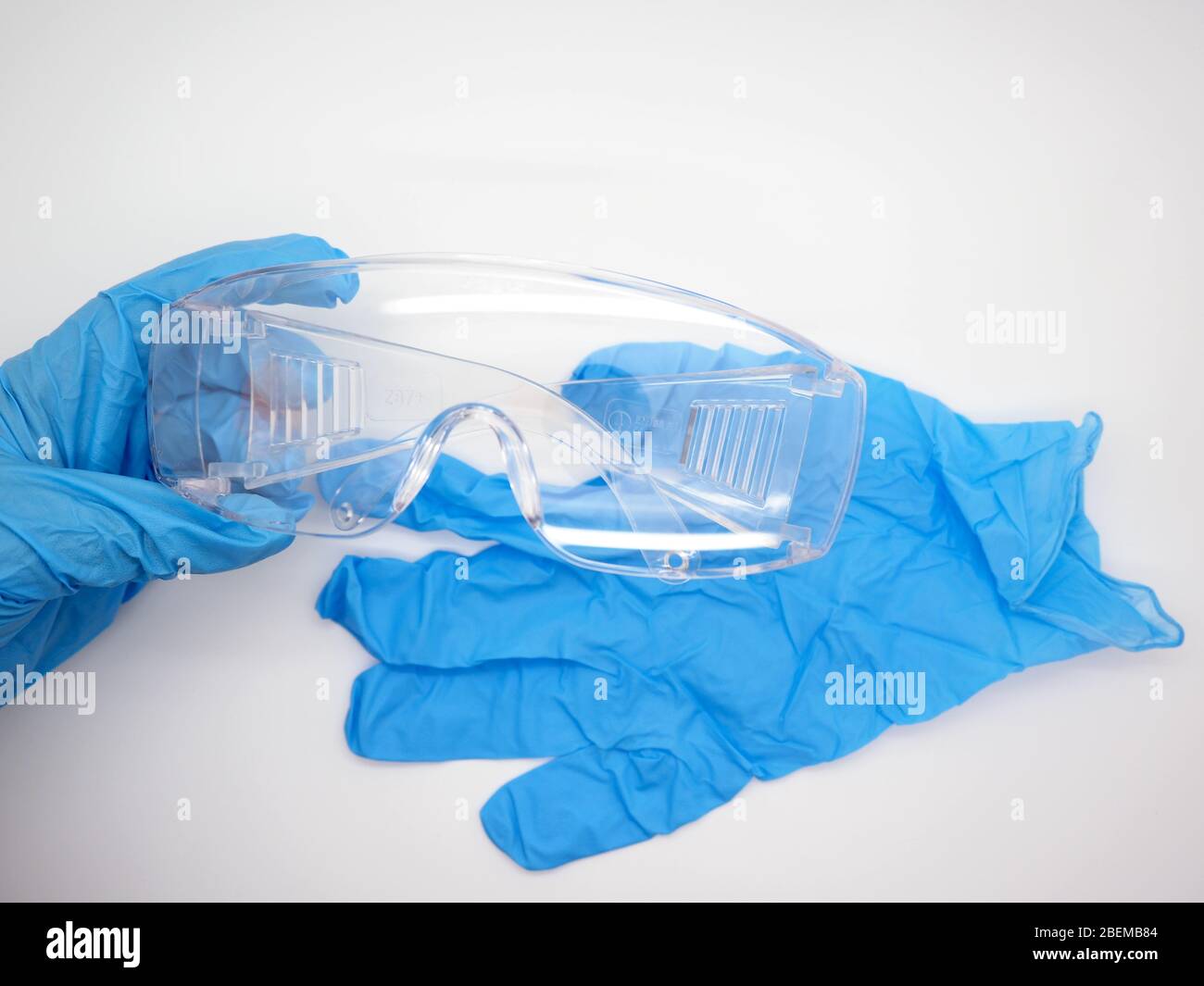 Hand Wearing A Blue Disposable Glove (PPE) Reaching Out And Picking Up ...